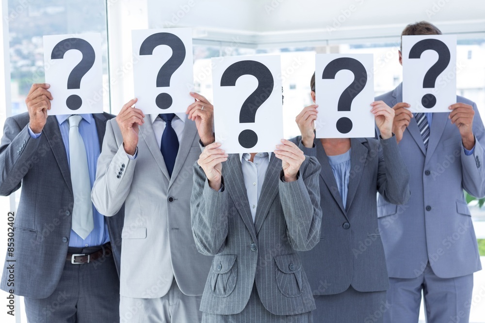 Foto de Business colleagues hiding their face with question mark sign ...