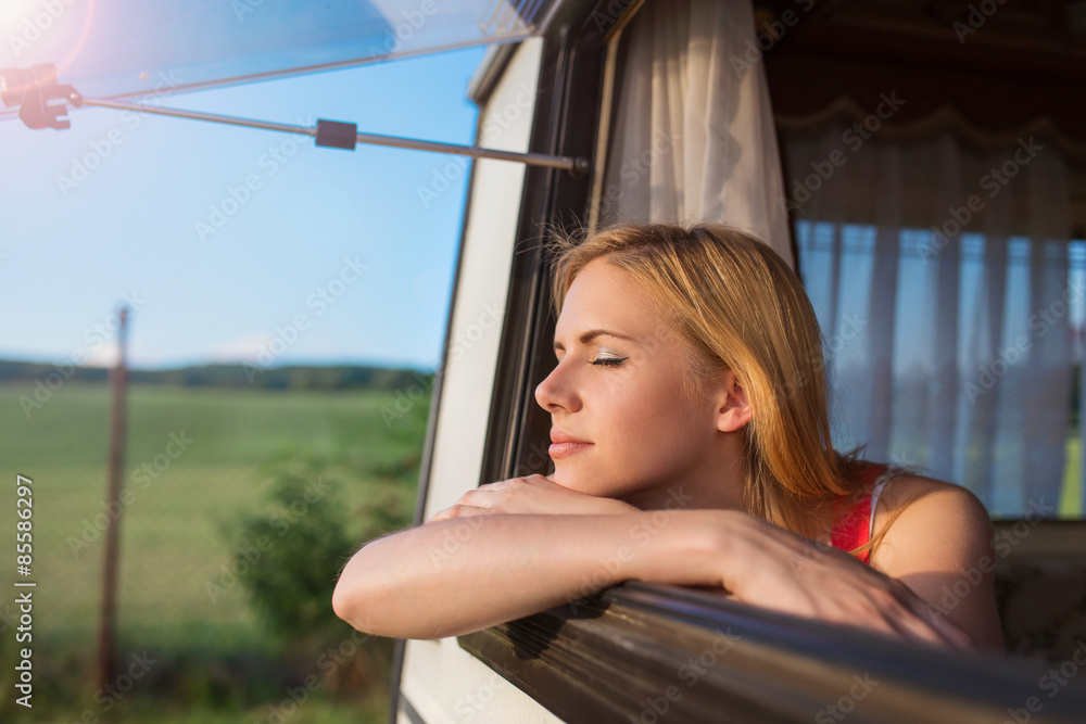 Beautiful woman sitting in a camper van Stock-Foto | Adobe Stock
