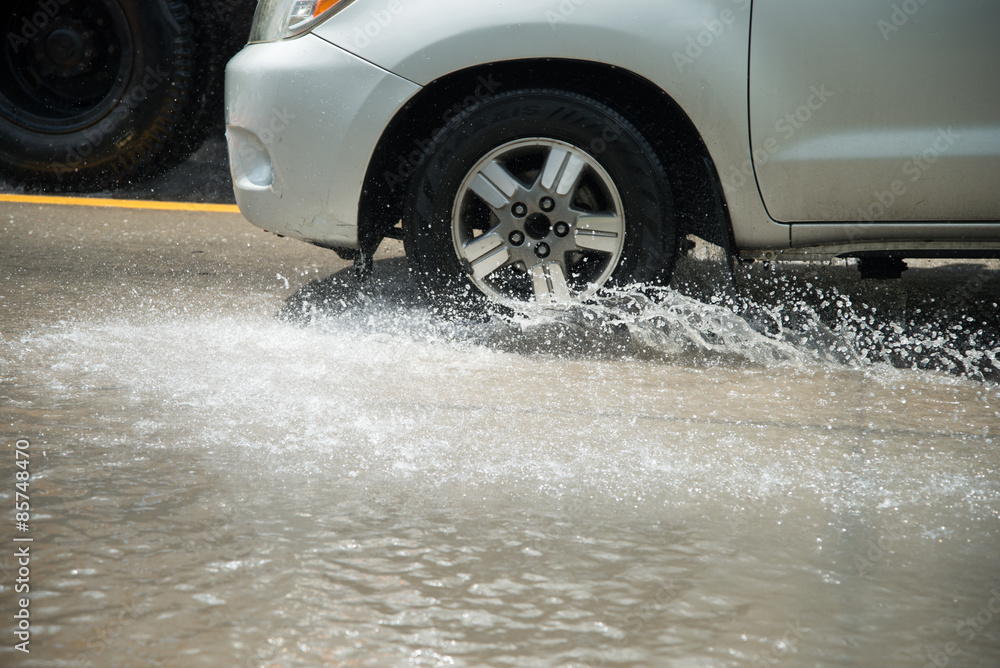 Car's wheels ride on water splashing on the road Stock Photo | Adobe Stock