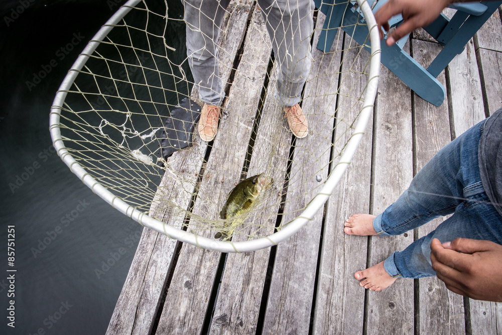 two men with a fish in net on a wood pontoon Stock Photo | Adobe Stock