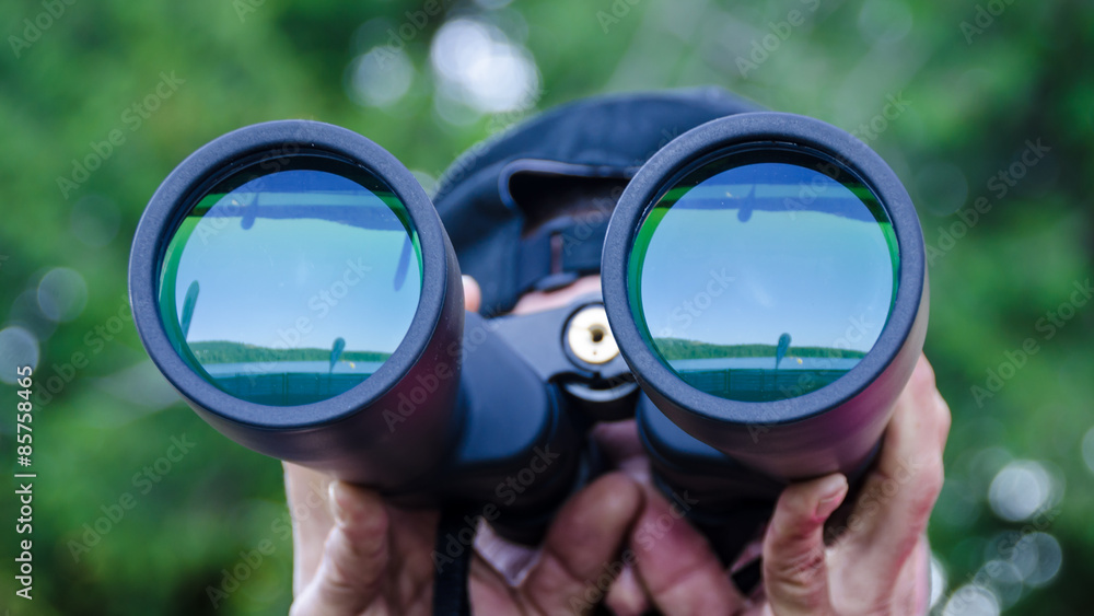 Man views swimmers on a lake during a race that are reflected on the ...