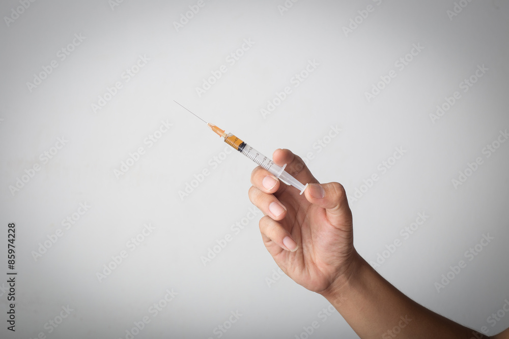 hand holding hypodermic needle Stock Photo | Adobe Stock