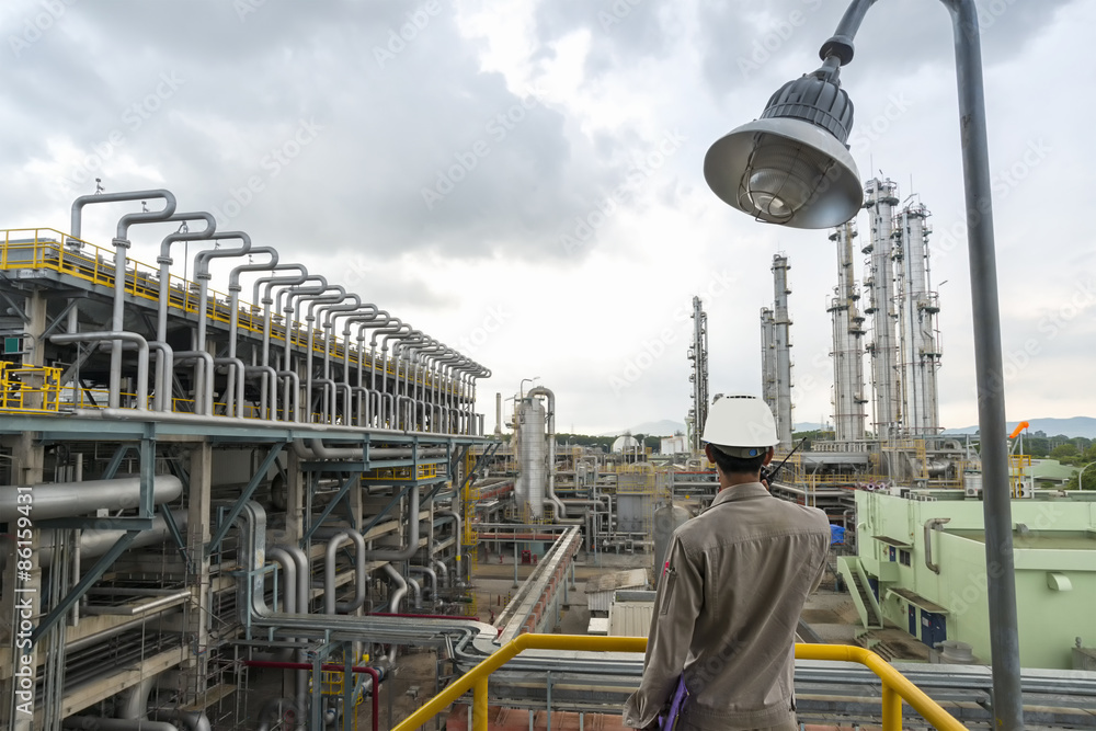 Back of operator wearing white safety helmet over refinery facto Stock ...