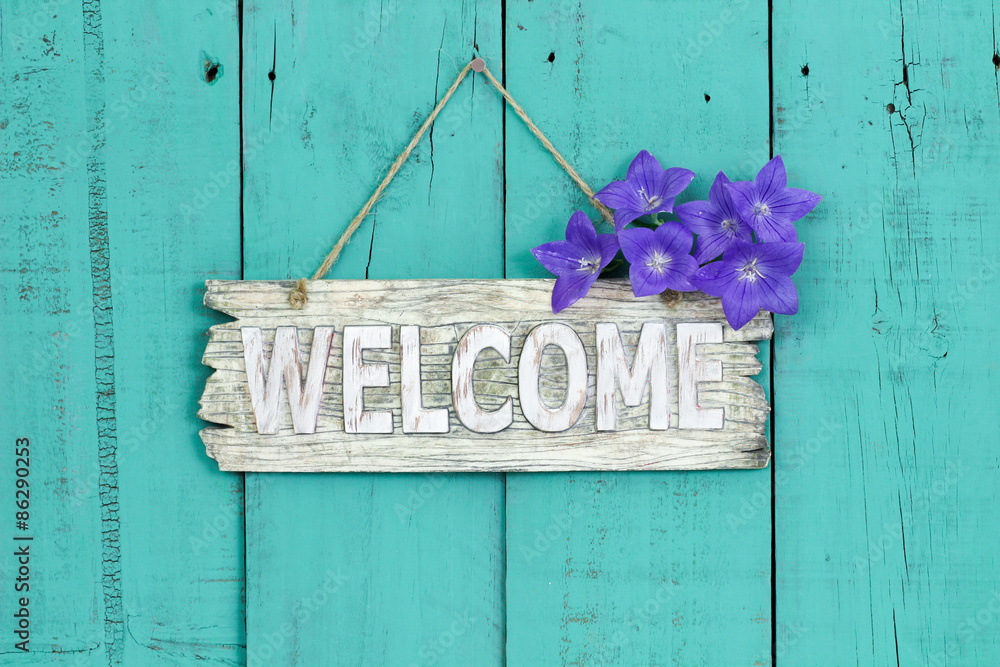 Welcome sign with flowers hanging on teal blue background Stock Photo ...