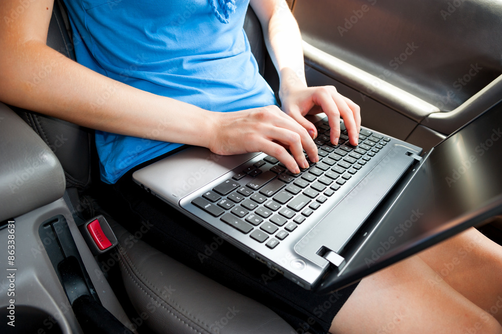 Unrecognizable businesswoman sitting in car with laptop computer on her ...
