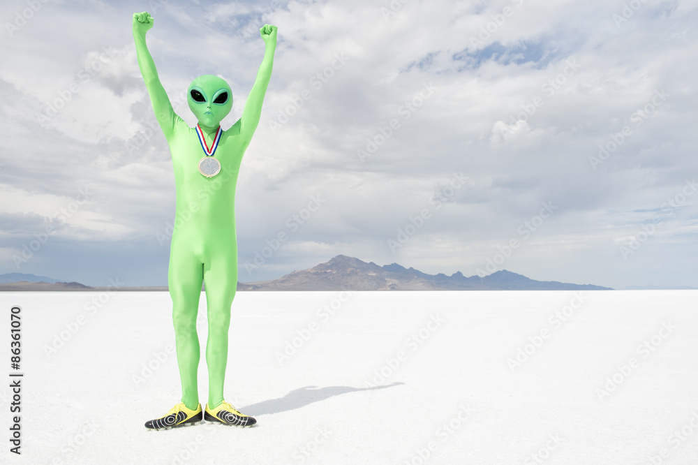 Green alien athlete wearing gold medal standing with arms raised on ...