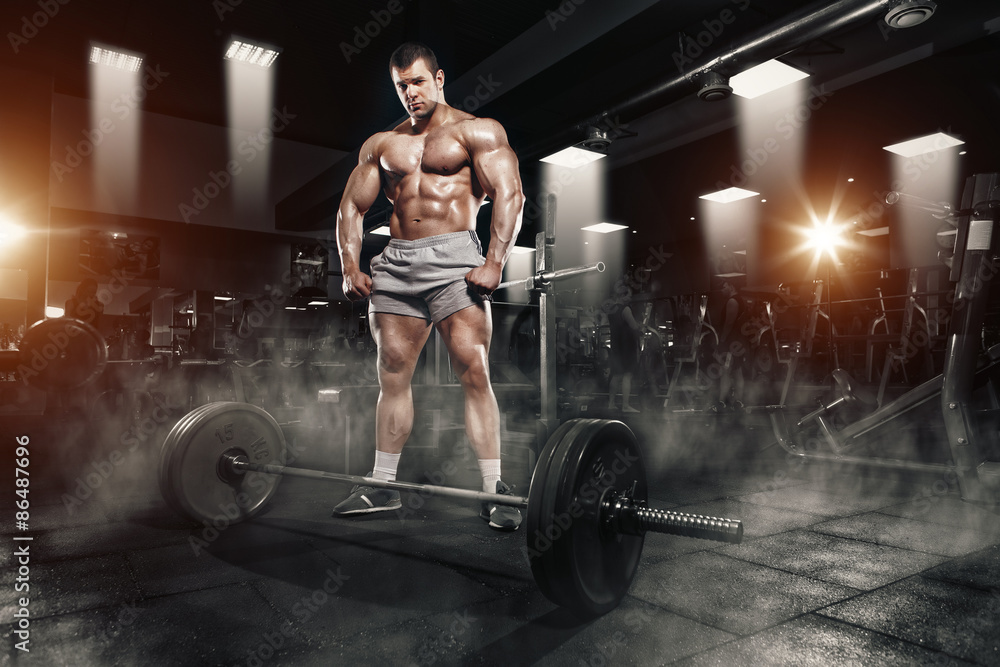 Athlete muscular bodybuilder in the gym training with barbell and ...