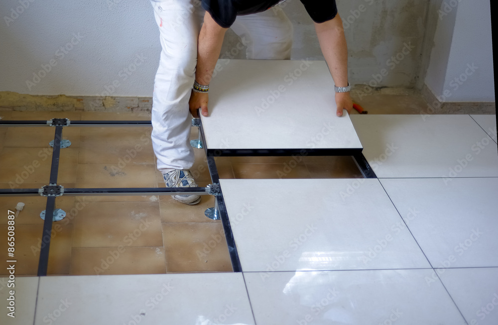 worker carries a floating floor on steel feet, resting on the structure ...