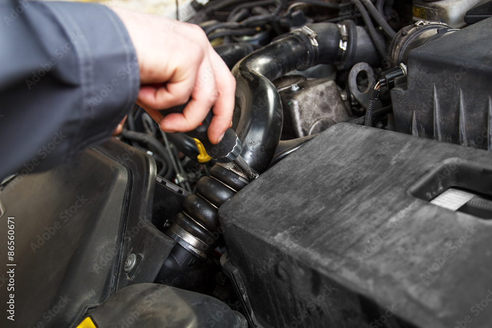 Car mechanic working under the engine hood of a car. Stock Photo ...