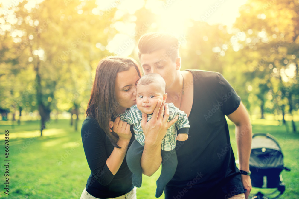 Mommy and daddy holding baby, 3 months old newborn and kissing him ...