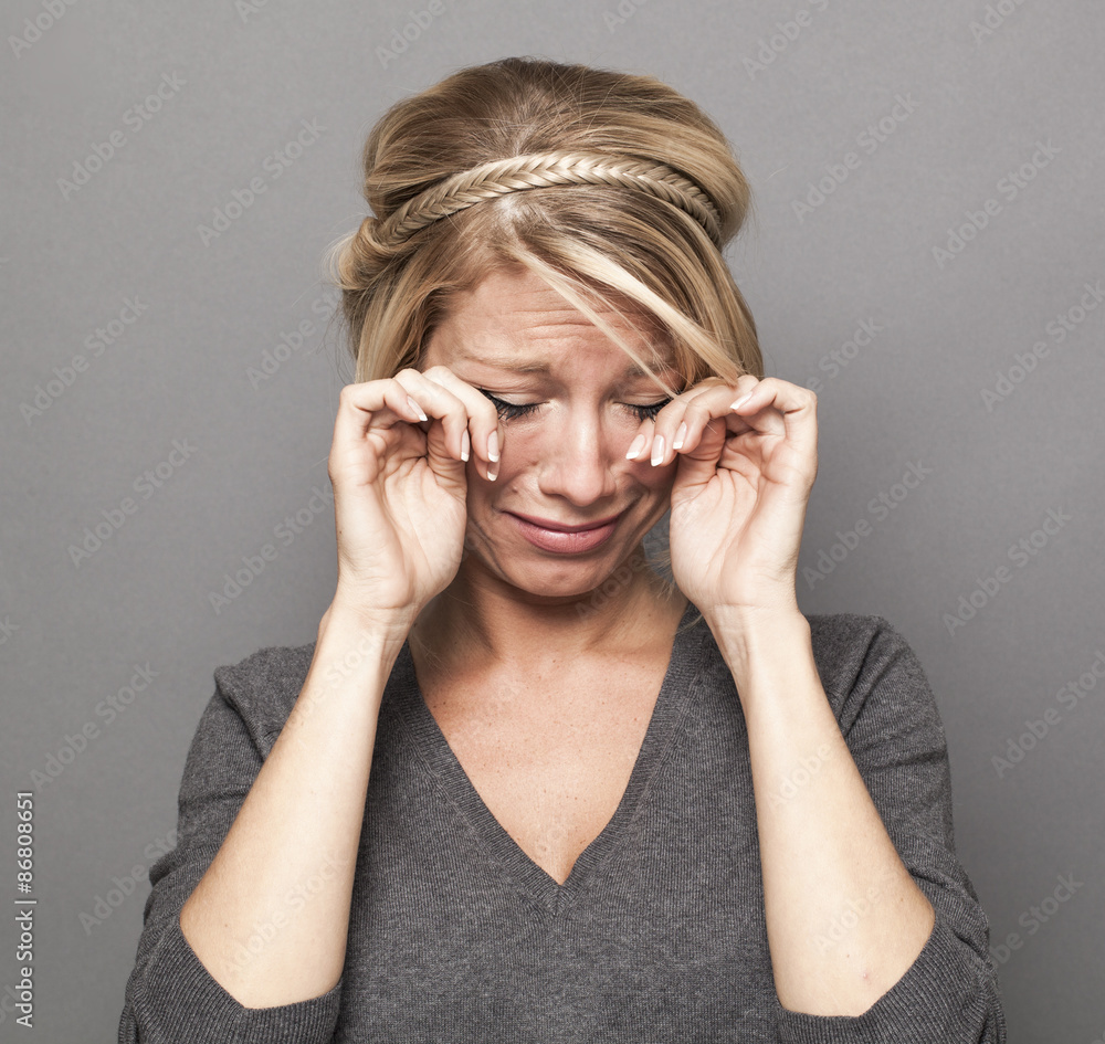 sad 30's sophisticated blonde girl wiping her tears, looking depressed ...
