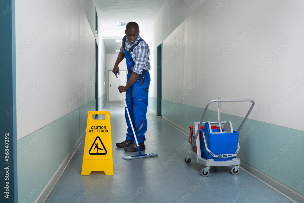 Male Janitor Mopping In Corridor Stock Photo | Adobe Stock