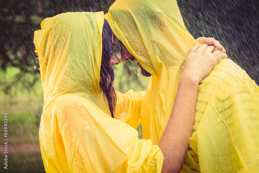 Cute couple wearing protection cape and hugging under the rain Stock ...