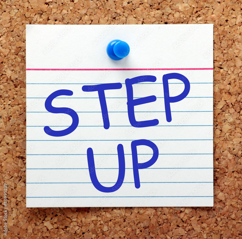 The phrase Step Up in blue text on an index card pinned to a cork ...