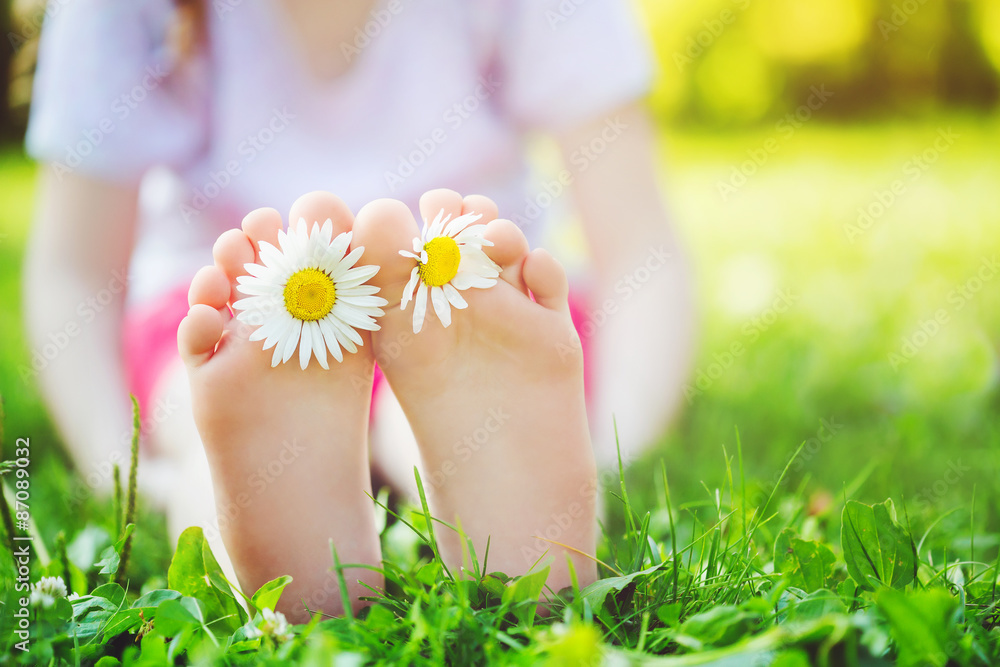 Child feet with daisy flower on green grass in a summer park. Stock ...