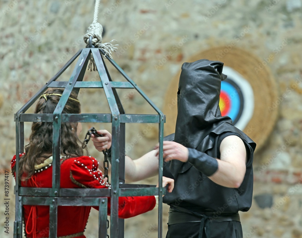 medieval EXECUTIONER with black cap on head and girl in cage Stock ...
