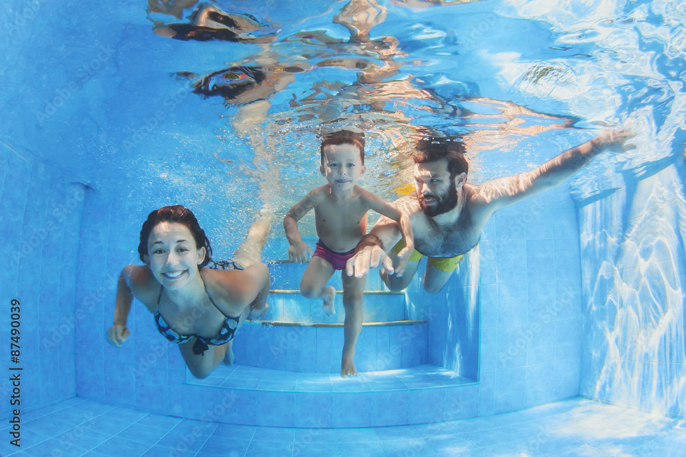 Happy family - father and mother with baby boy swimming and diving ...