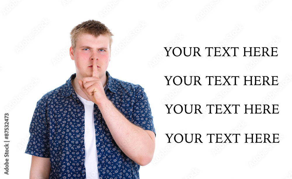 Portrait of young man placing finger on lips as if to say, "shhhhh ...