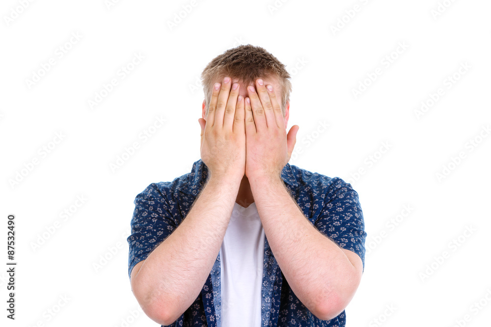Closeup portrait of young blond man covering face by two hands ...