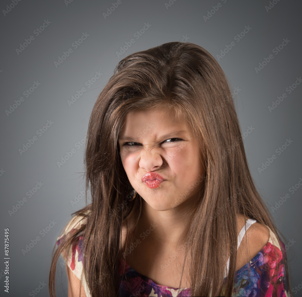 Grimacing girl, studio shot, gray background Stock Photo | Adobe Stock