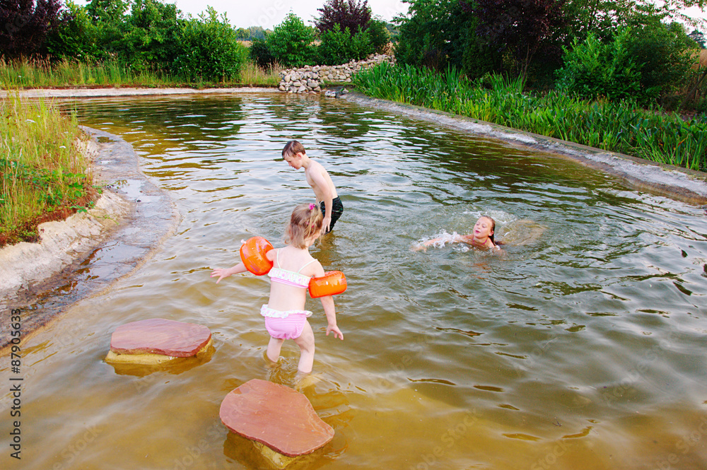 Spielende Kinder beim Baden und Planschen in einem Naturteich. Stock ...