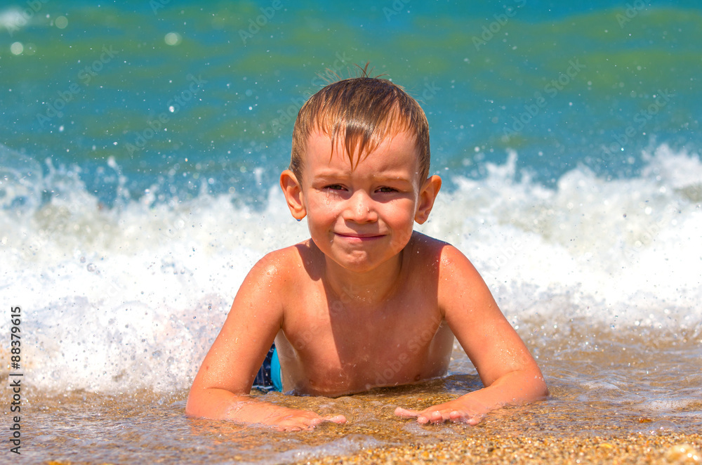 Little boy bathing in the sea when the waves, lying on the sand Stock ...