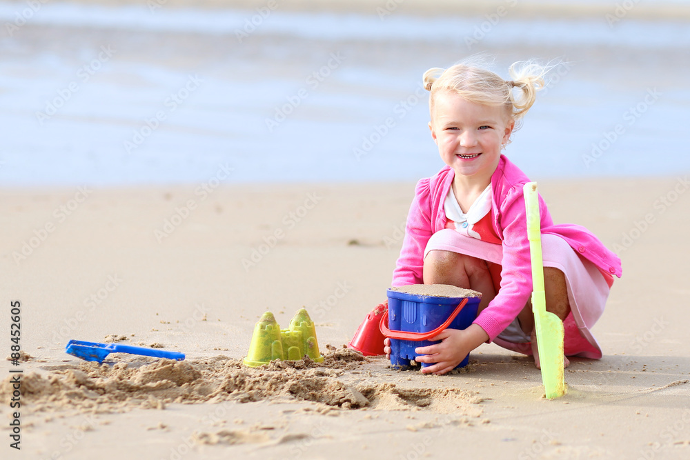Cute active child playing on sandy beach. Happy little girl enjoying ...