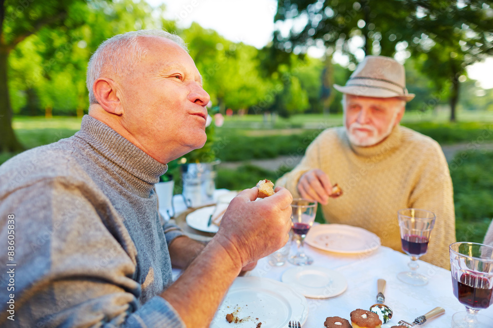 Mann isst Kuchen im Garten mit Freunden Stock Photo | Adobe Stock