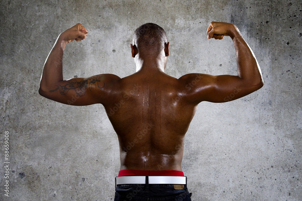 Shirtless fit black man in hip hop style clothing flexing back muscle ...