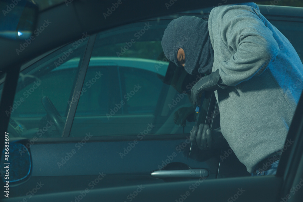 Car thief stealing a car on the parking lot. Stock-Foto | Adobe Stock