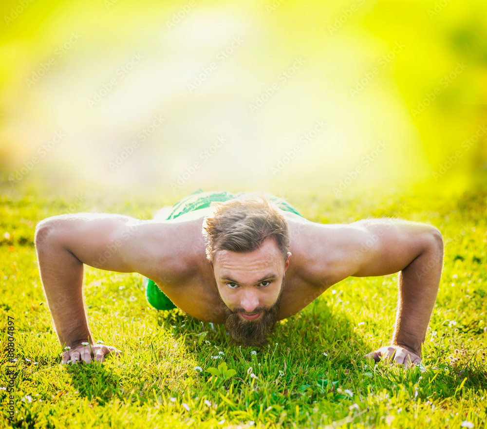 Sports man with brown hair and a beard on a natural background ...