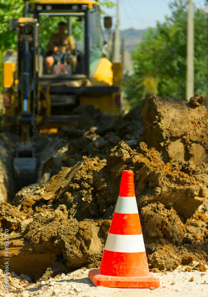 excavation works/ the warning road cone against a soil and the ...