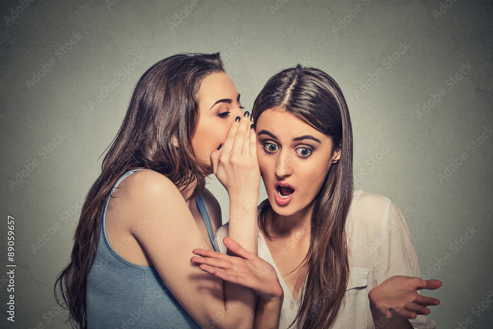 Girl whispering into woman ear telling her shocking secret Stock Photo ...