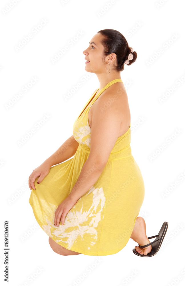 Pretty woman in yellow dress kneeling. Stock Photo | Adobe Stock