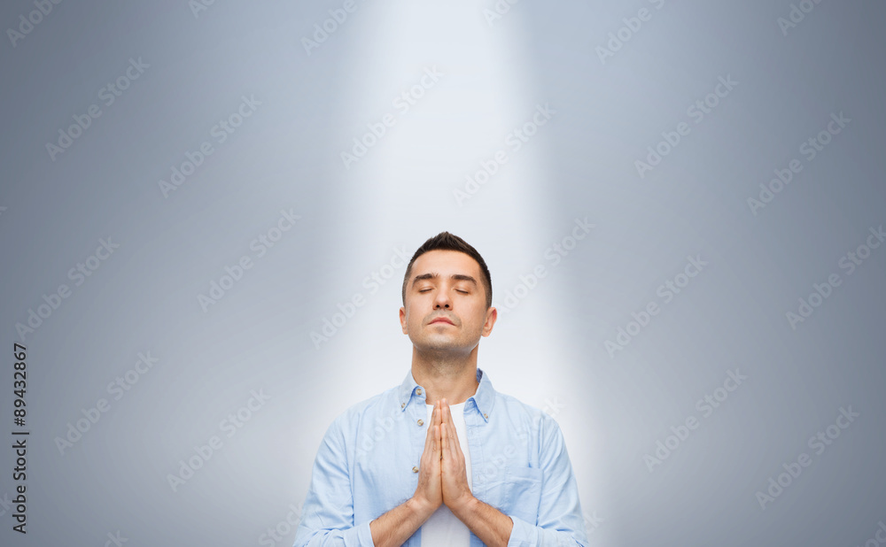 man praying under ray of ligh Stock Photo | Adobe Stock