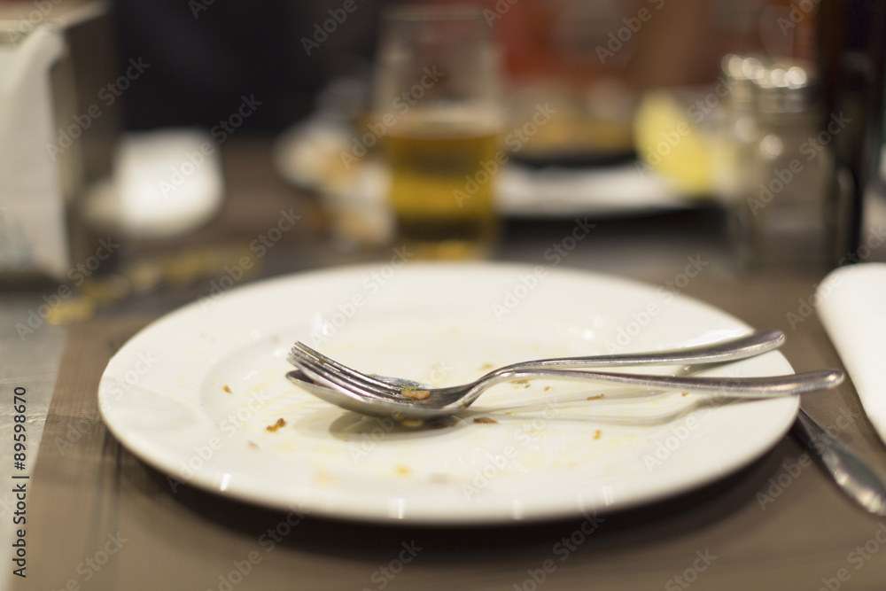 Empty plate of food after meal on a table Stock Photo | Adobe Stock