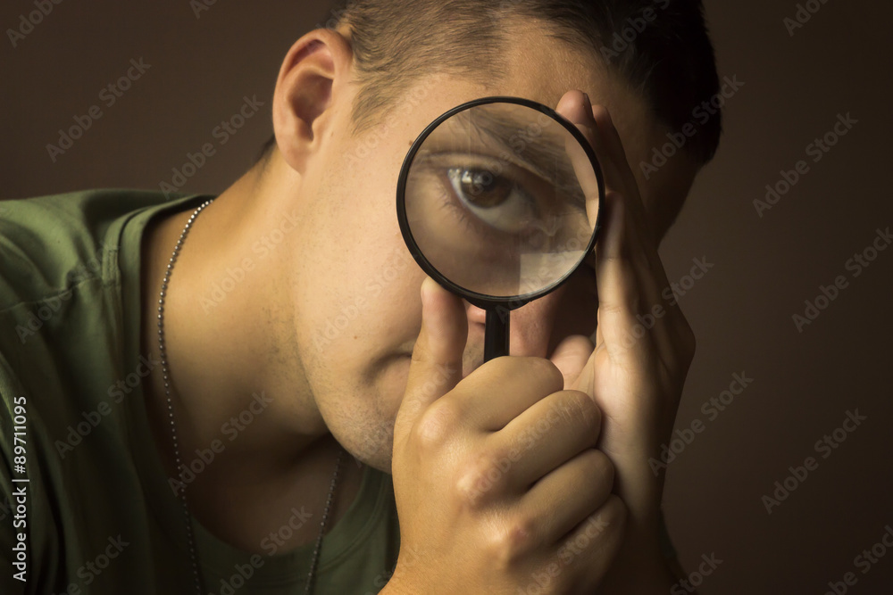 Vintage photo. A young guy looking through a magnifying glass Stock ...