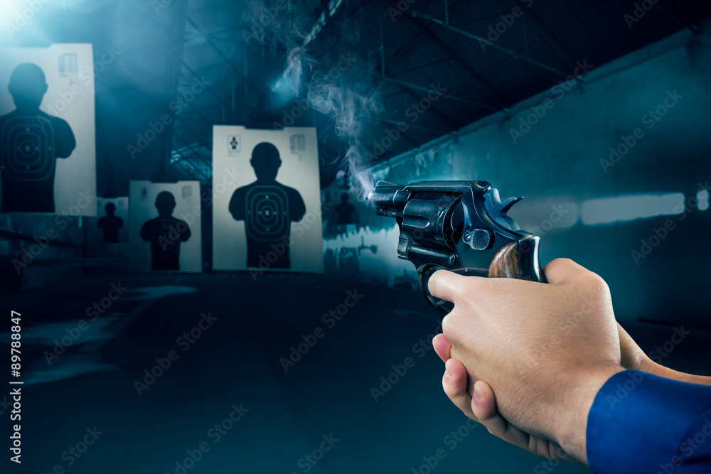 Police officer firing a gun at a shooting range / dramatic light Stock ...