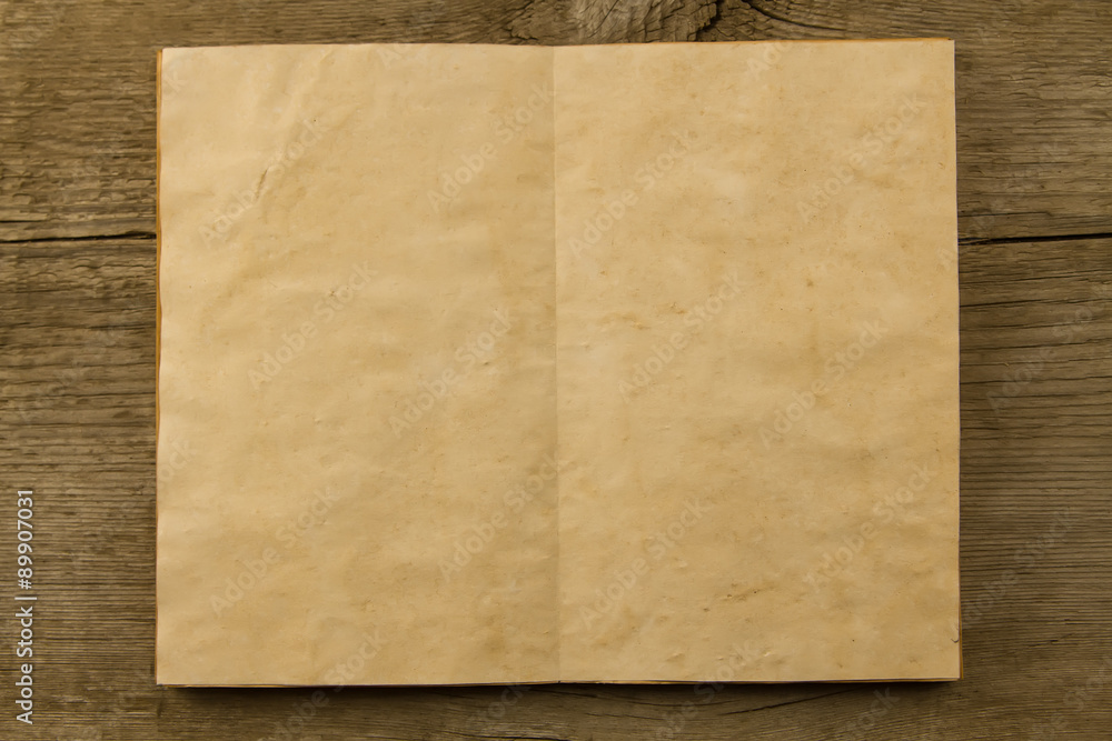 open old vintage book on the aged wooden background. Two clean sheet of ...