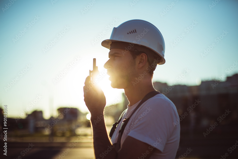 Engineer builder using a walkie talkie giving instructions at a ...