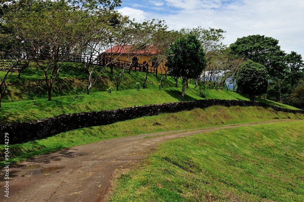 Dirt road under retaining wall by the chapel in Turrialba, Costa Rica ...