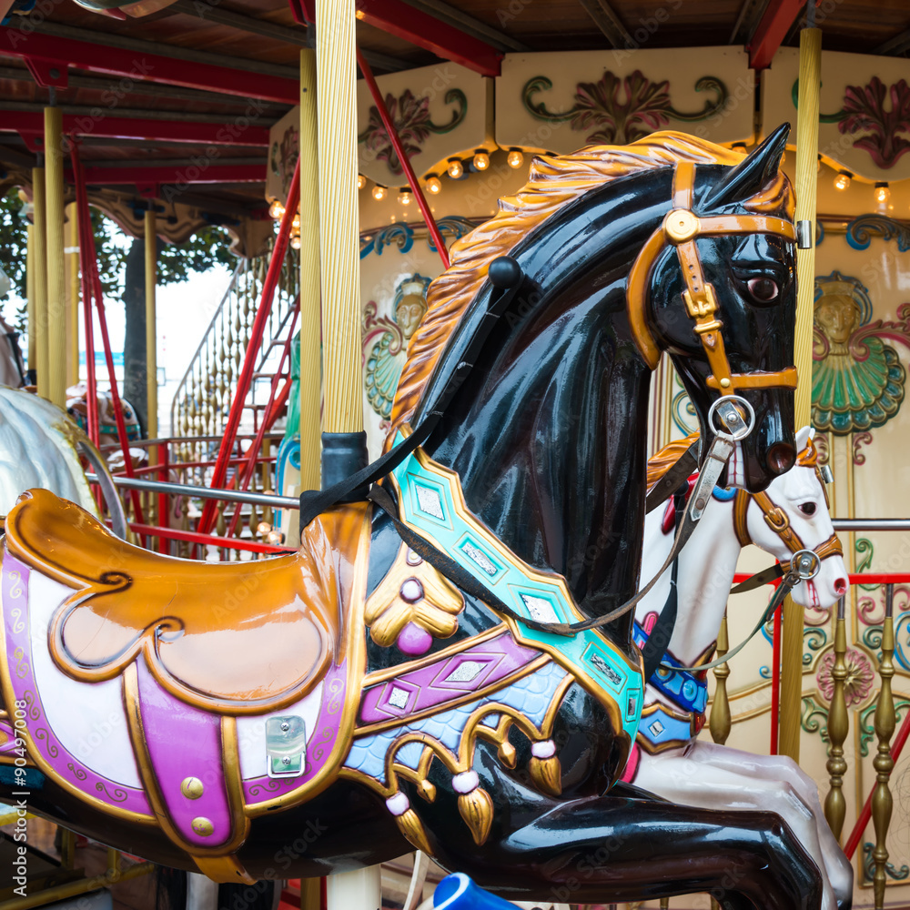 Old French carousel in a holiday park. Three horses and airplane on a ...