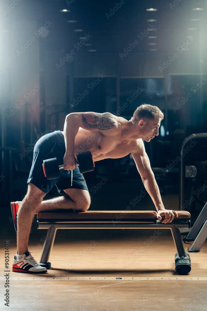 Athlete muscular bodybuilder training back with dumbbell in the Stock ...