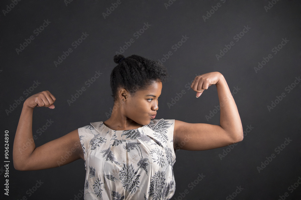 African American woman with strong arms on blackboard background Stock ...