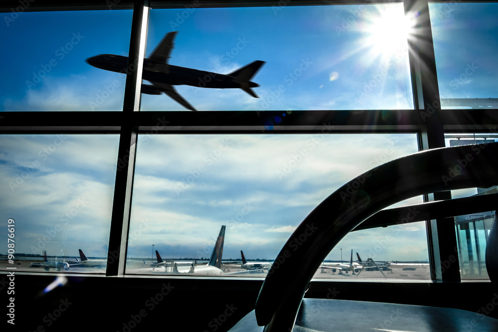 Looking at a airplane taking off from the inside of a lounge in the ...