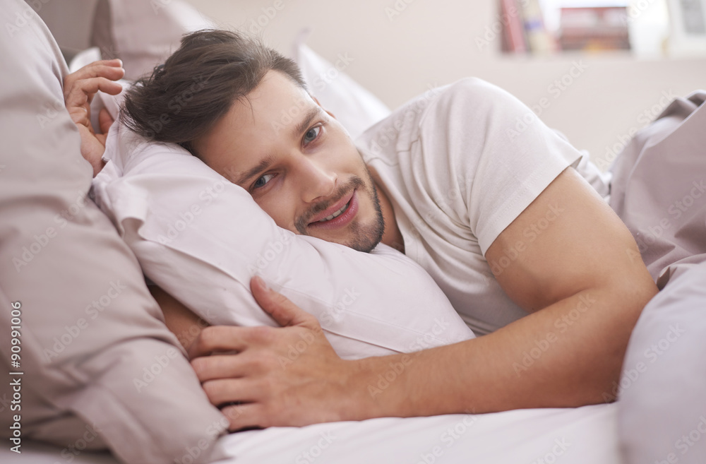 Rested man lying down in his bed in the morning Stock 사진 | Adobe Stock