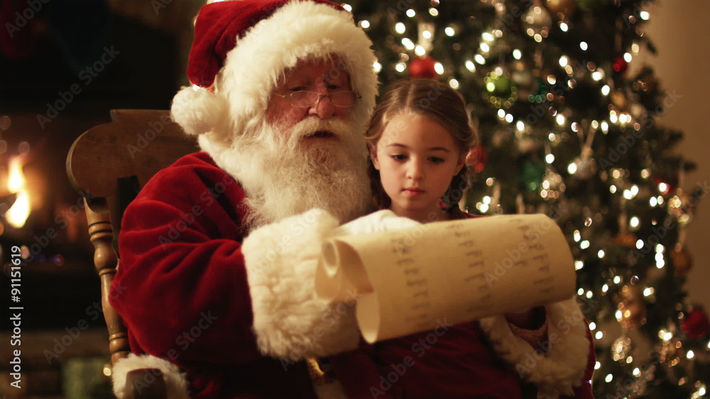 Santa Claus reading a list with a girl on his lap Stock Video | Adobe Stock