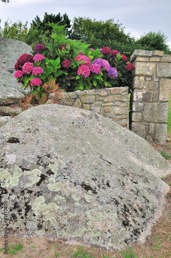 Joli devanture composée de roches , de fleurs et d'un muret en granit ...