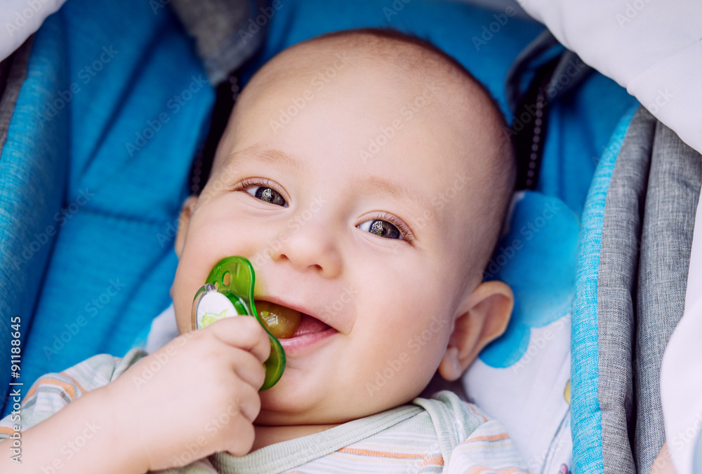 happy baby with pacifier in a stroller Stock-Foto | Adobe Stock