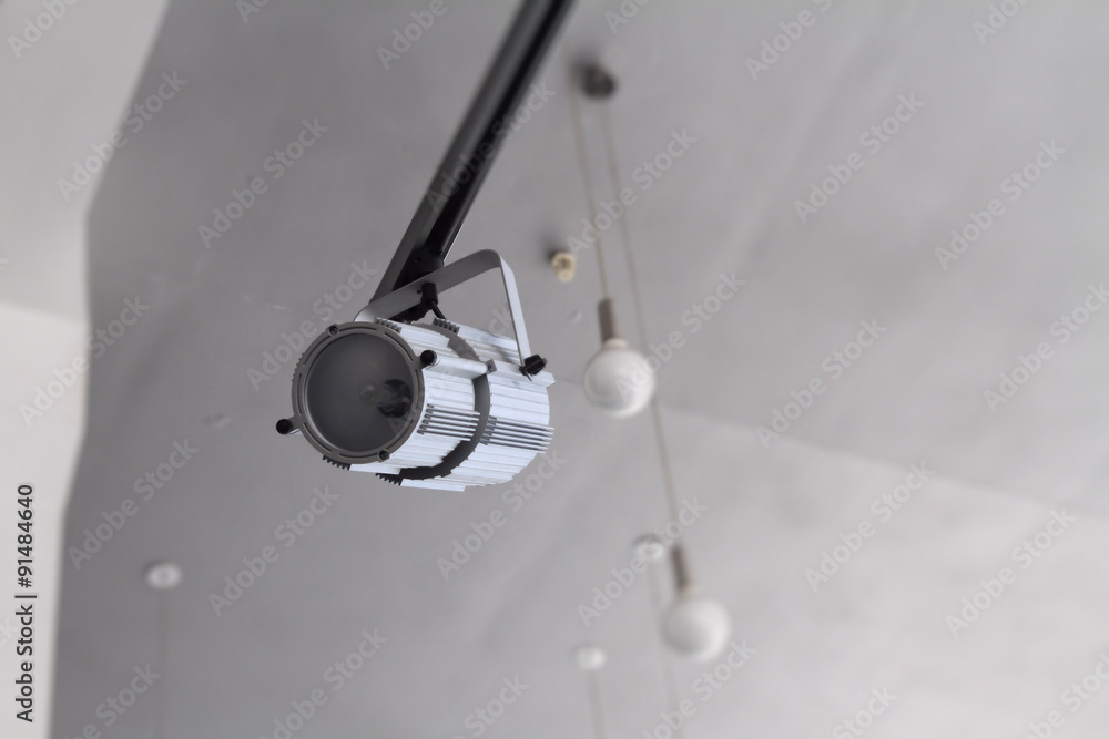 Track spotlight on rail system and round lights hanging from ceiling ...